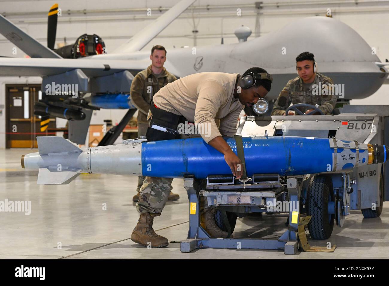 Airmen from the 29th Aircraft Maintenance Unit load an inert munition to a MJ-1 bomb lift truck ...