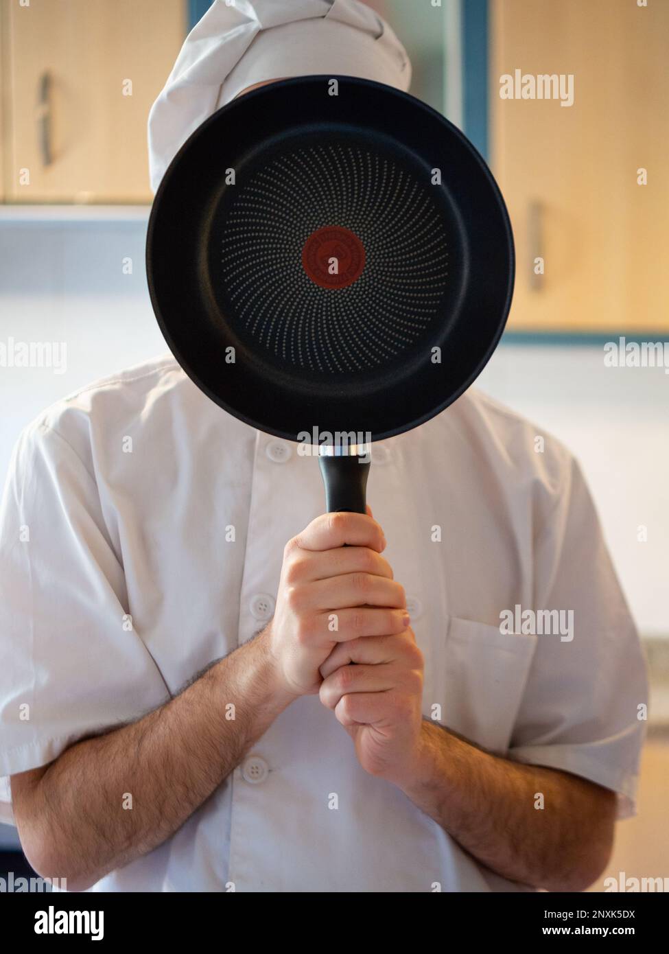 Portrait of a chef hiding his face with a non stick pan Stock Photo - Alamy