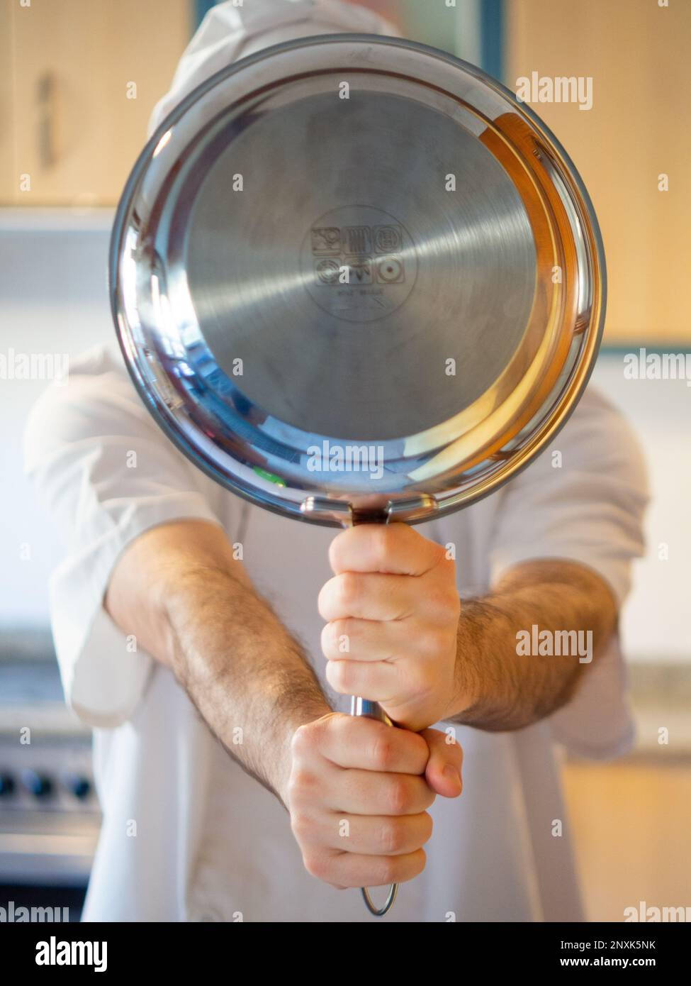 Portrait of a chef hiding his face with a stainless pan Stock Photo - Alamy
