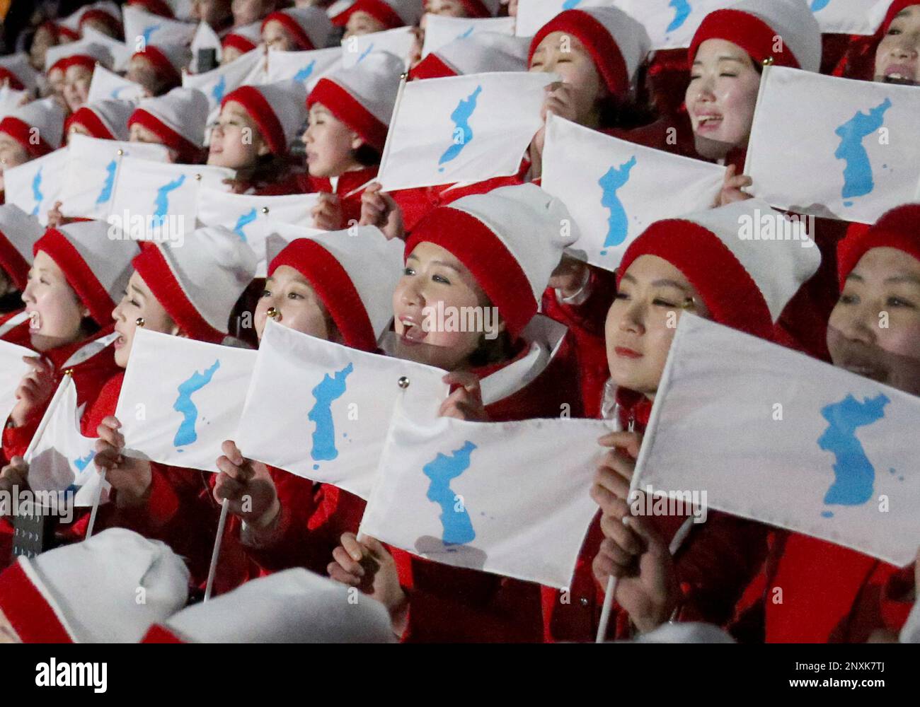 North Korean cheer group members hold unify flags during an opening ...