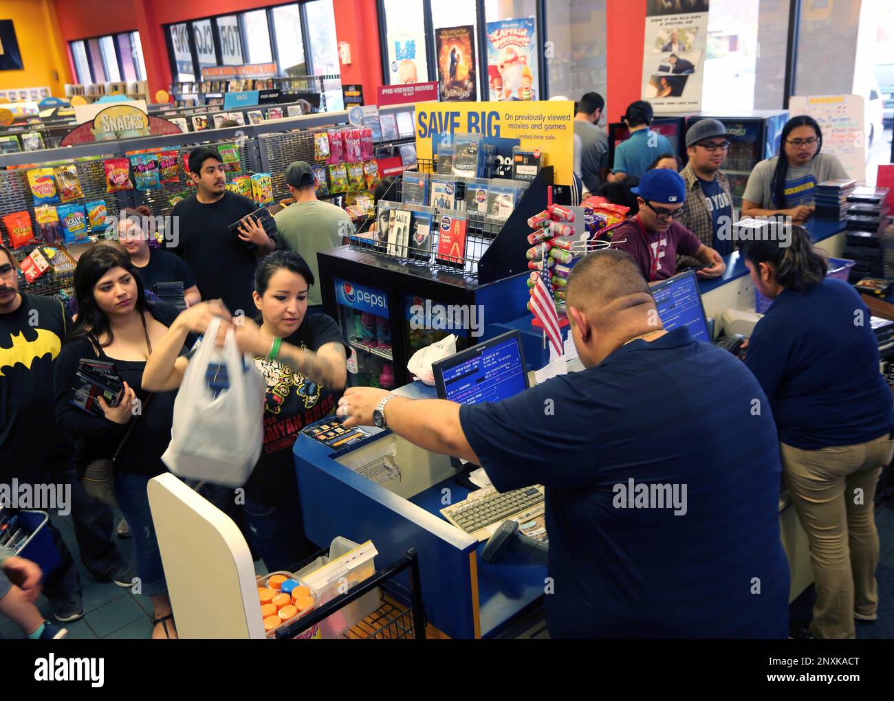 Monik Lopez, left, buys a bag full of movies from Rick Cavazos during ...