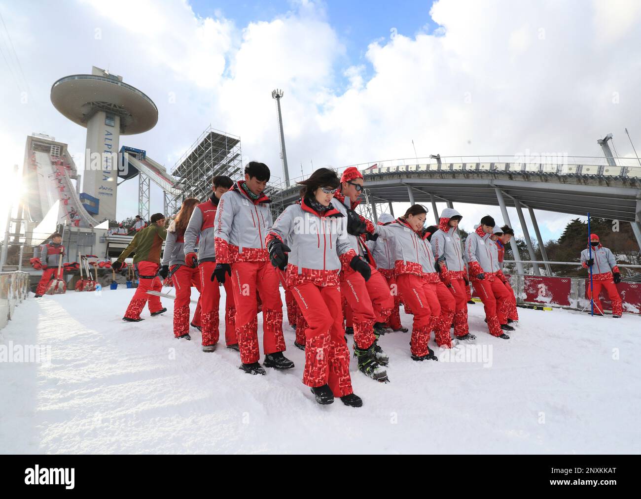 Volunteers tread down a ski-jump ramp to maintain at the Alpensia Ski ...