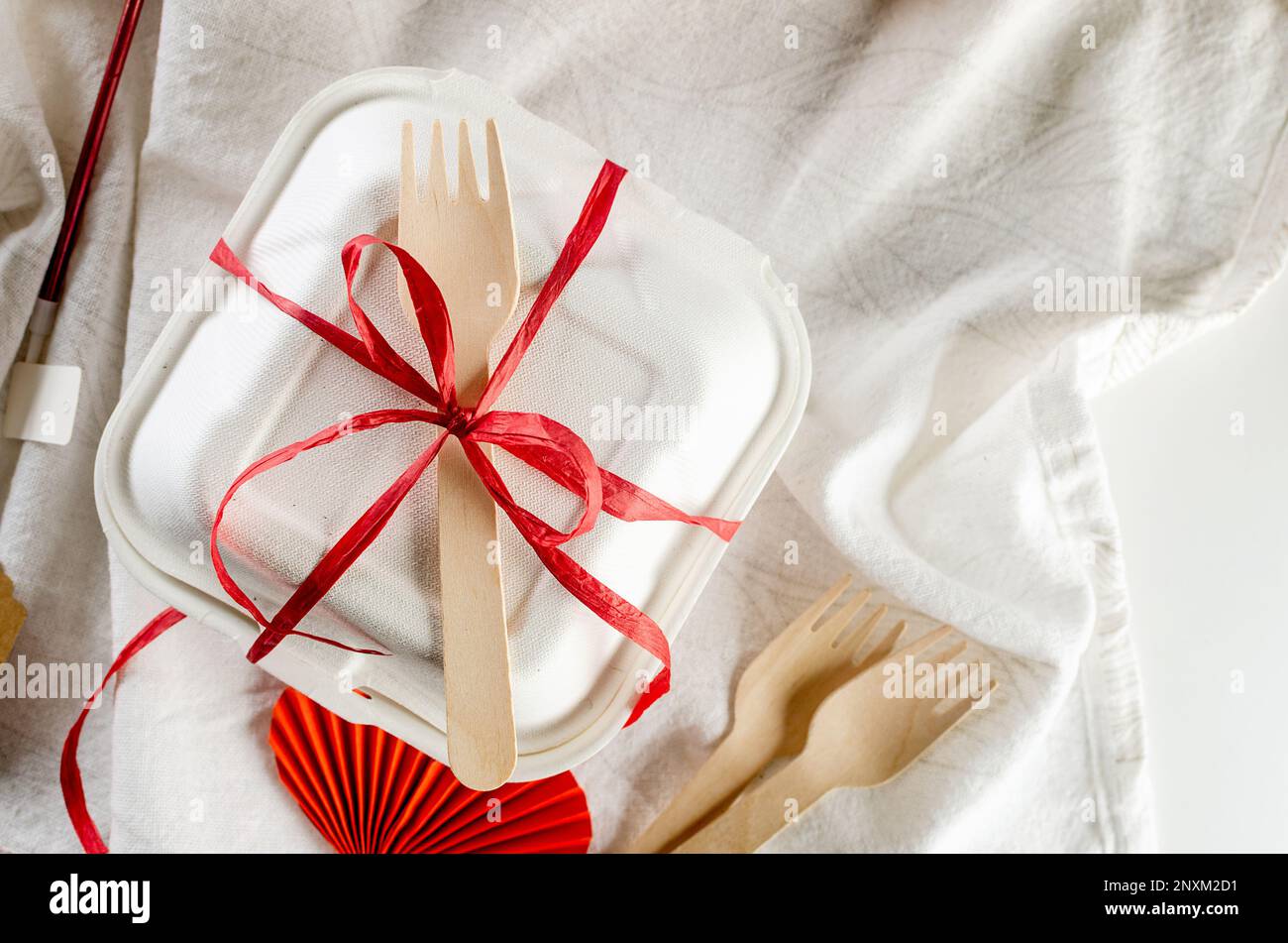 Closed bento cake box with a wooden spoon tied red ribbon. Gift box ...