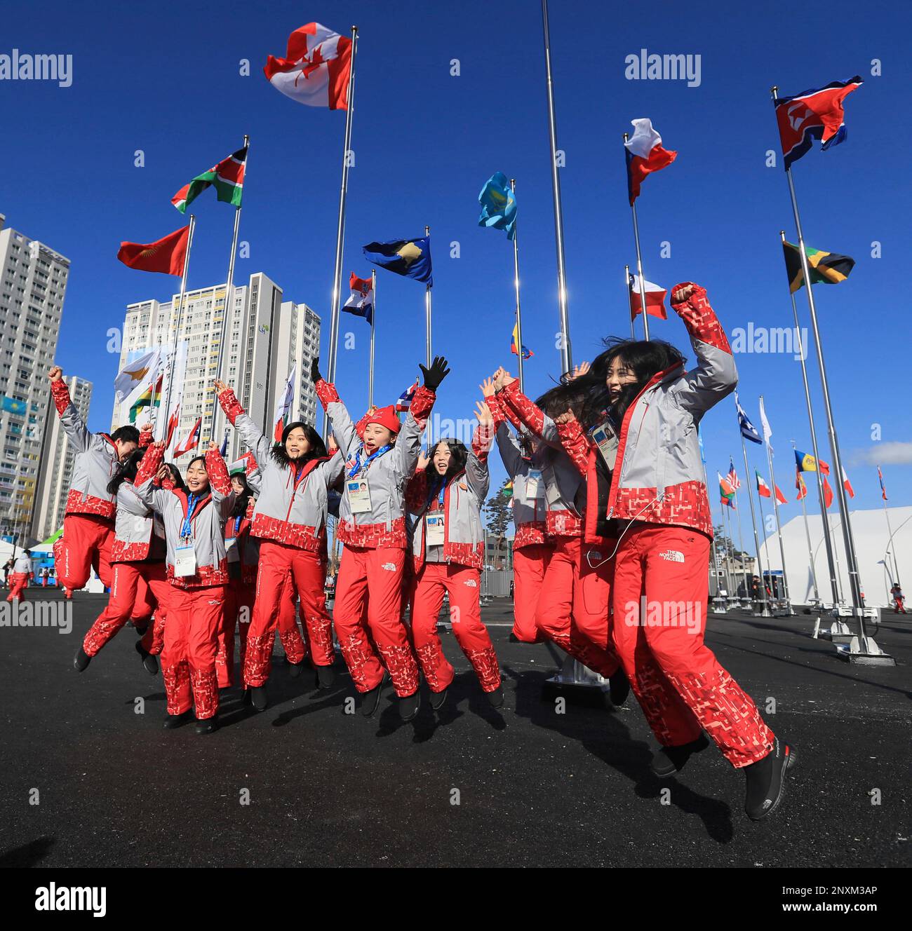 Volunteers celebrate during an opening ceremony of Olympic Village for ...
