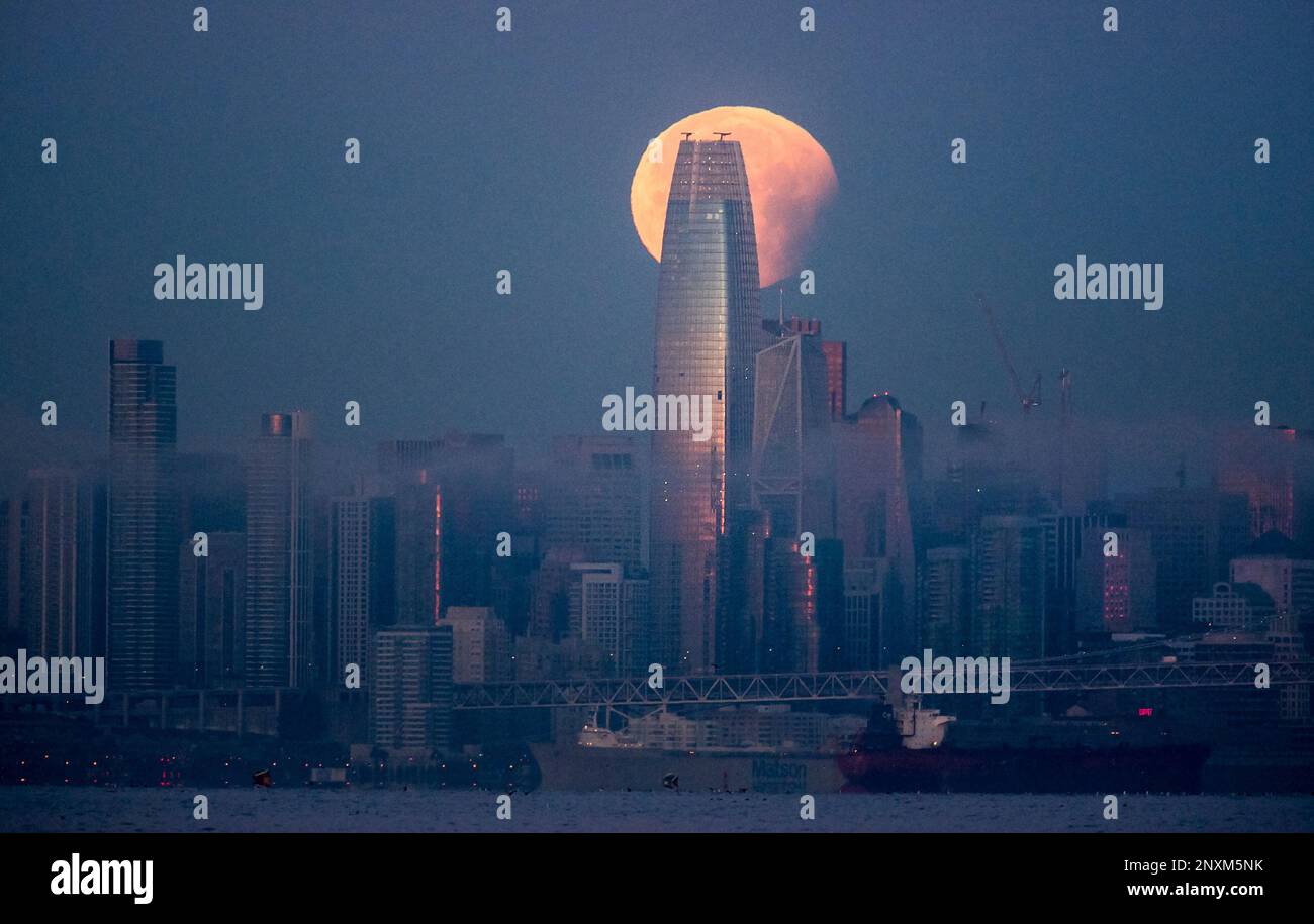 A partially-eclipsed super blue blood moon sets behind the Salesforce ...