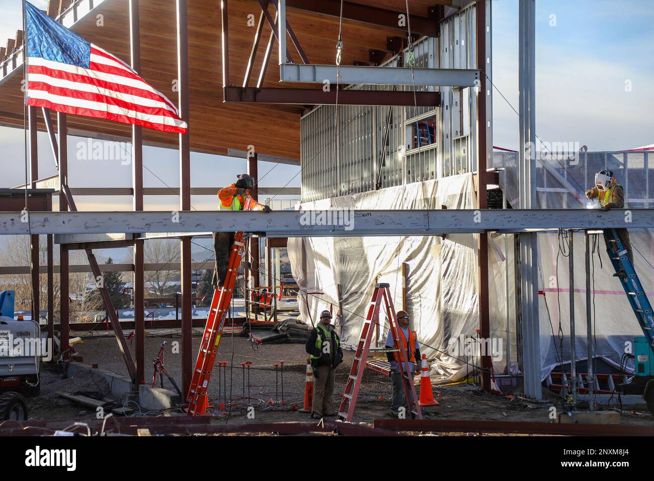 Workers weld the final steel beam into place of the new Eagle Valley ...