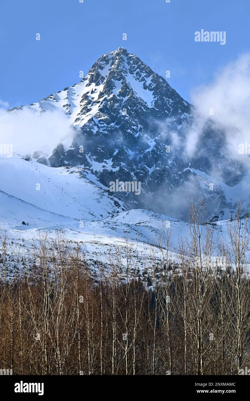 Scenic view of Vysoké Tatry mountain range with snow, misty clouds and ...