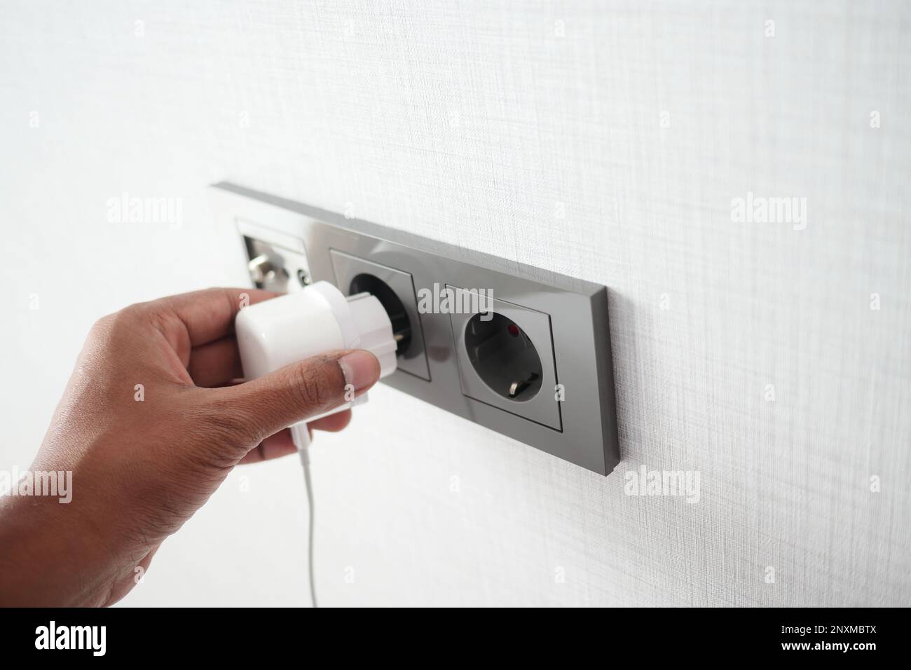 white color power cord cable plugged into wall Stock Photo - Alamy