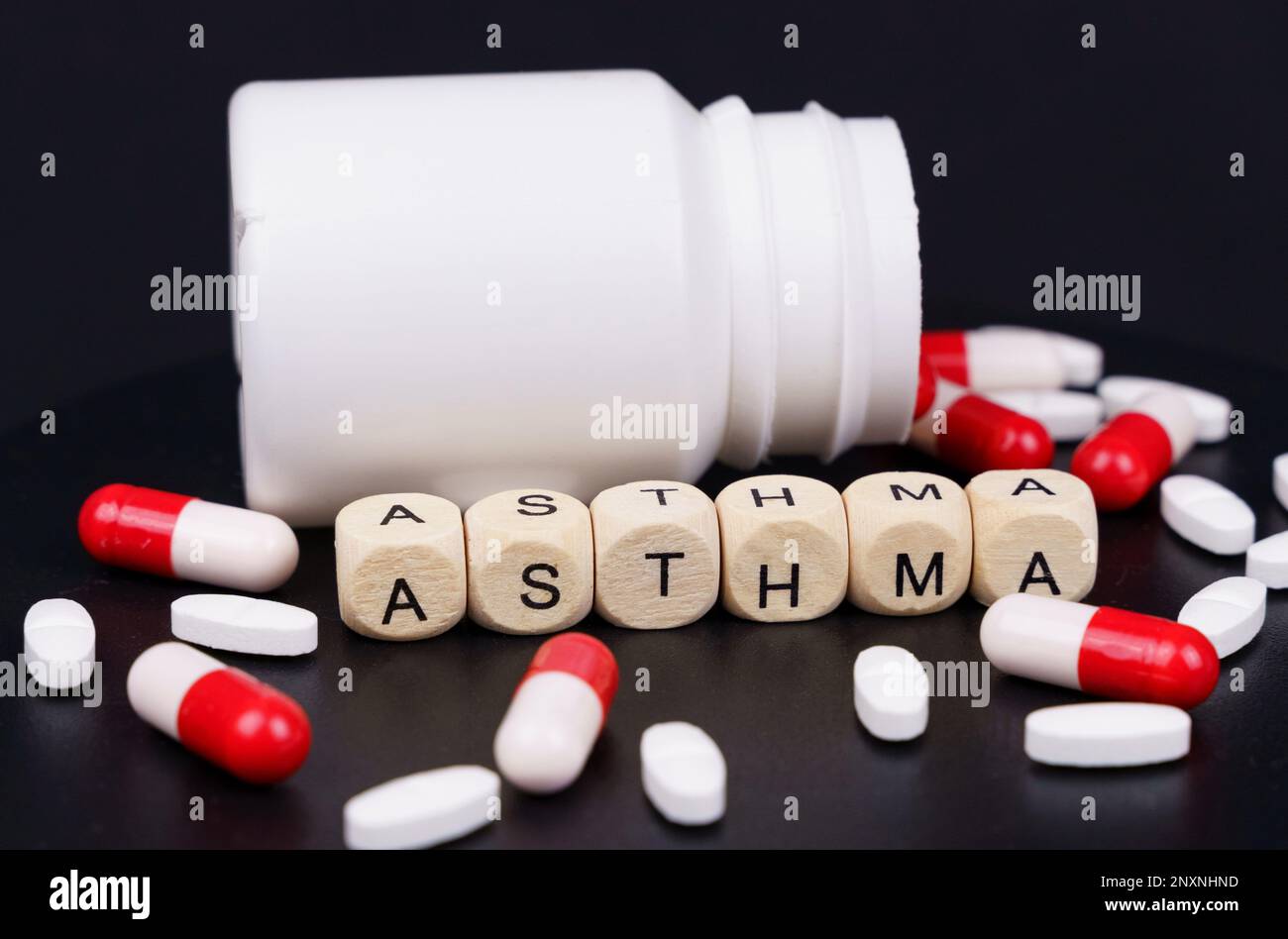 Medical concept. On a black background are red-white capsules, tablets ...