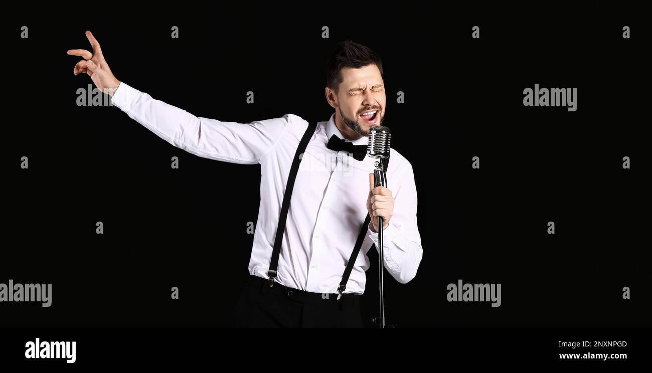 Emotional man singing on dark background Stock Photo - Alamy