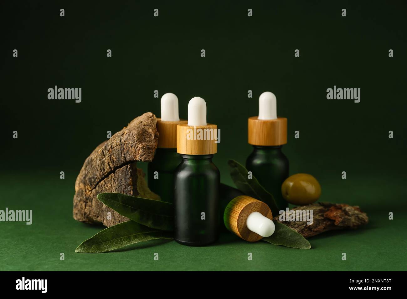Bottles of olive essential oil on green background Stock Photo - Alamy