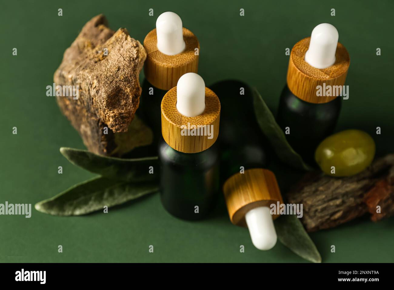 Bottles of olive essential oil on green background Stock Photo - Alamy