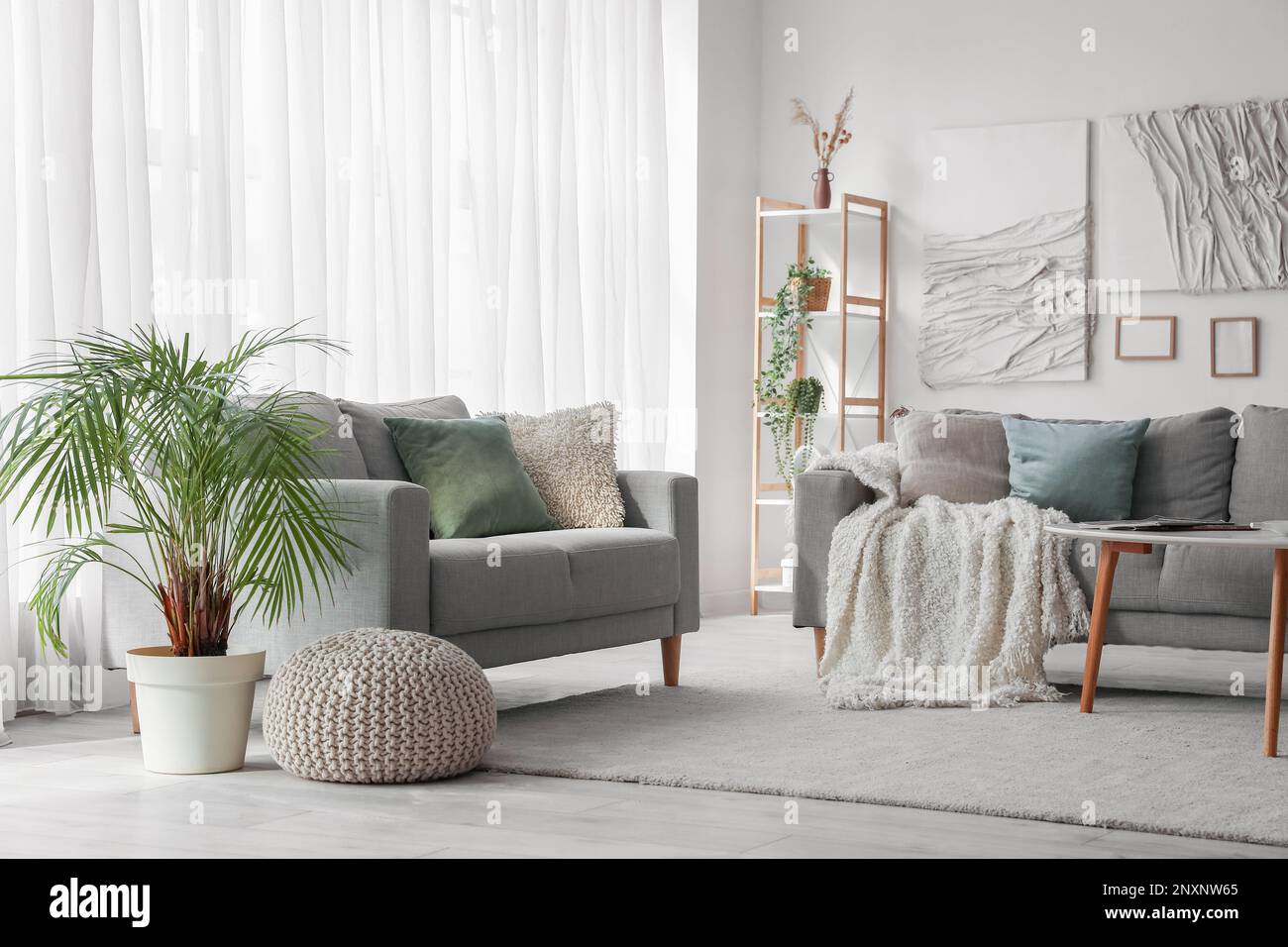 Interior of modern living room with sofas, table and creative artwork ...