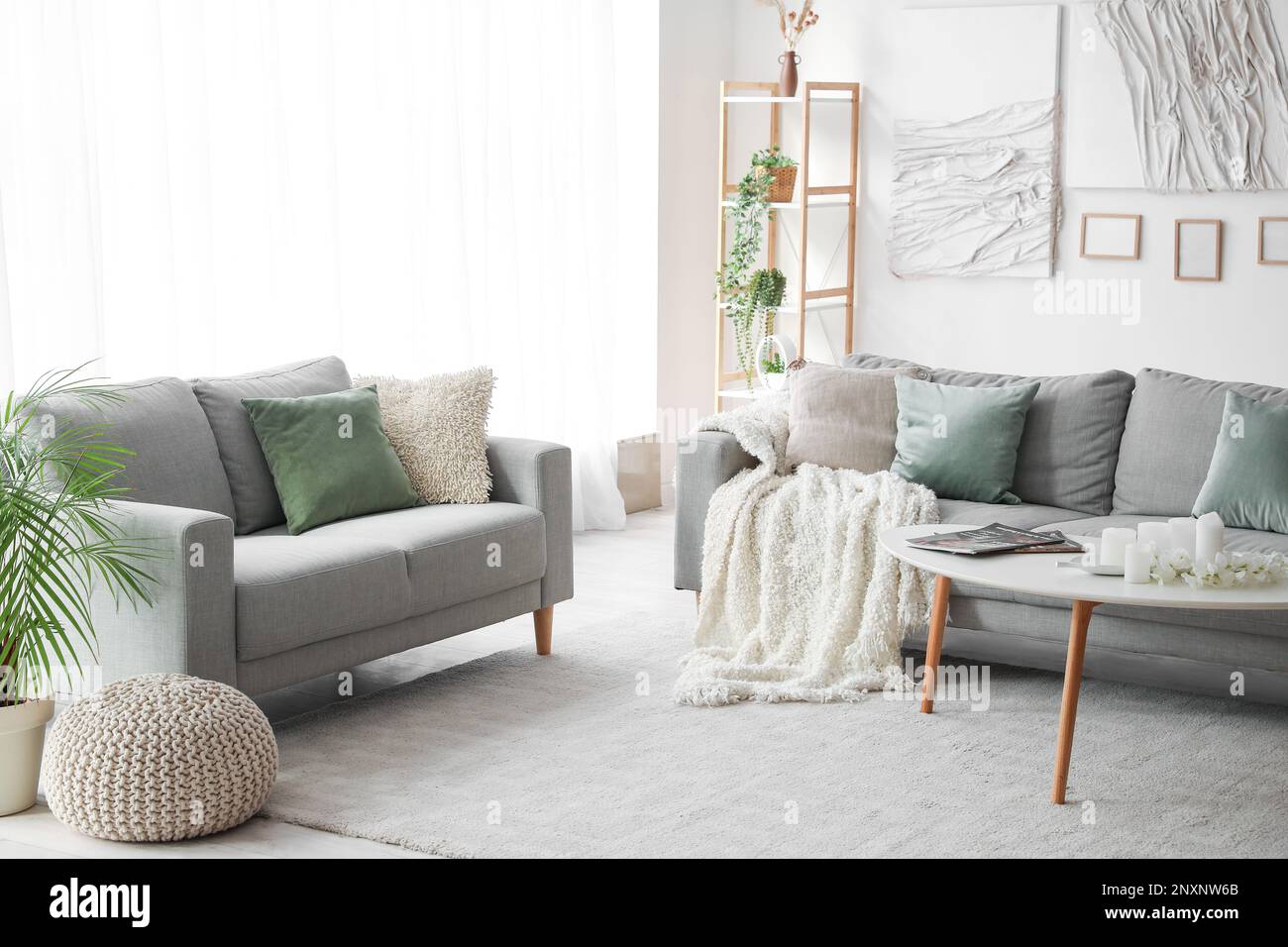 Interior of modern living room with sofas, table and creative artwork ...