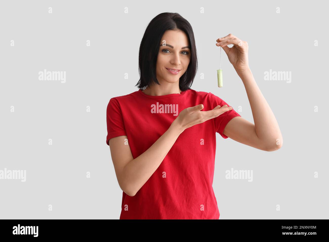 Young woman with tampon on grey background Stock Photo - Alamy