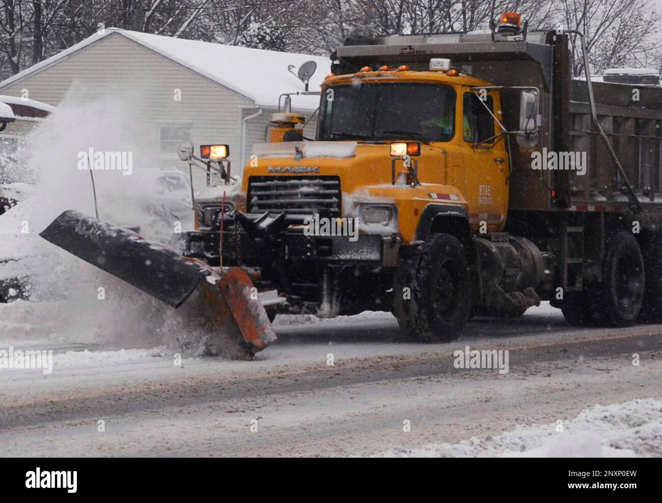 Snow flies up from the blade as a worker from the Pennsylvania ...