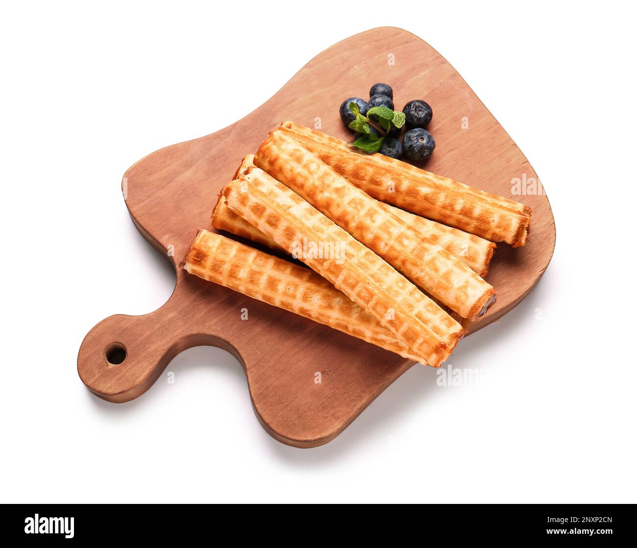 Board with delicious wafer rolls and blueberries isolated on white ...
