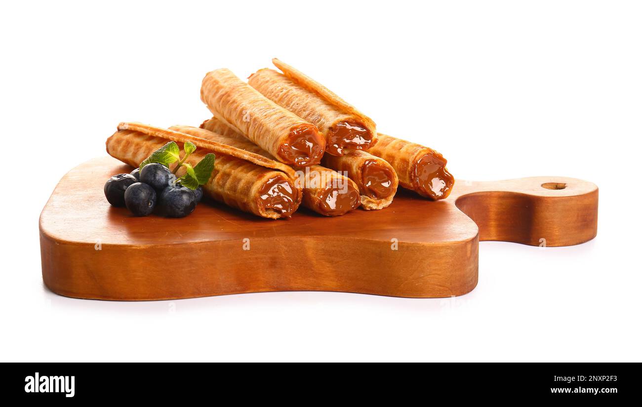 Board with delicious wafer rolls and blueberries isolated on white ...