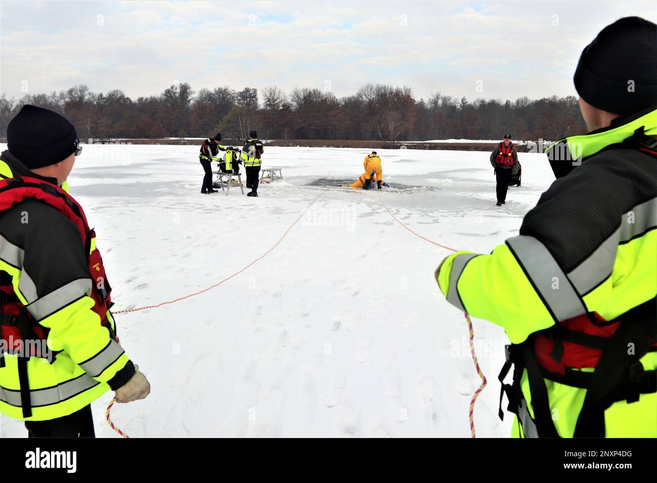 Firefighters wearing cold-water immersion protective suits hold surface ...