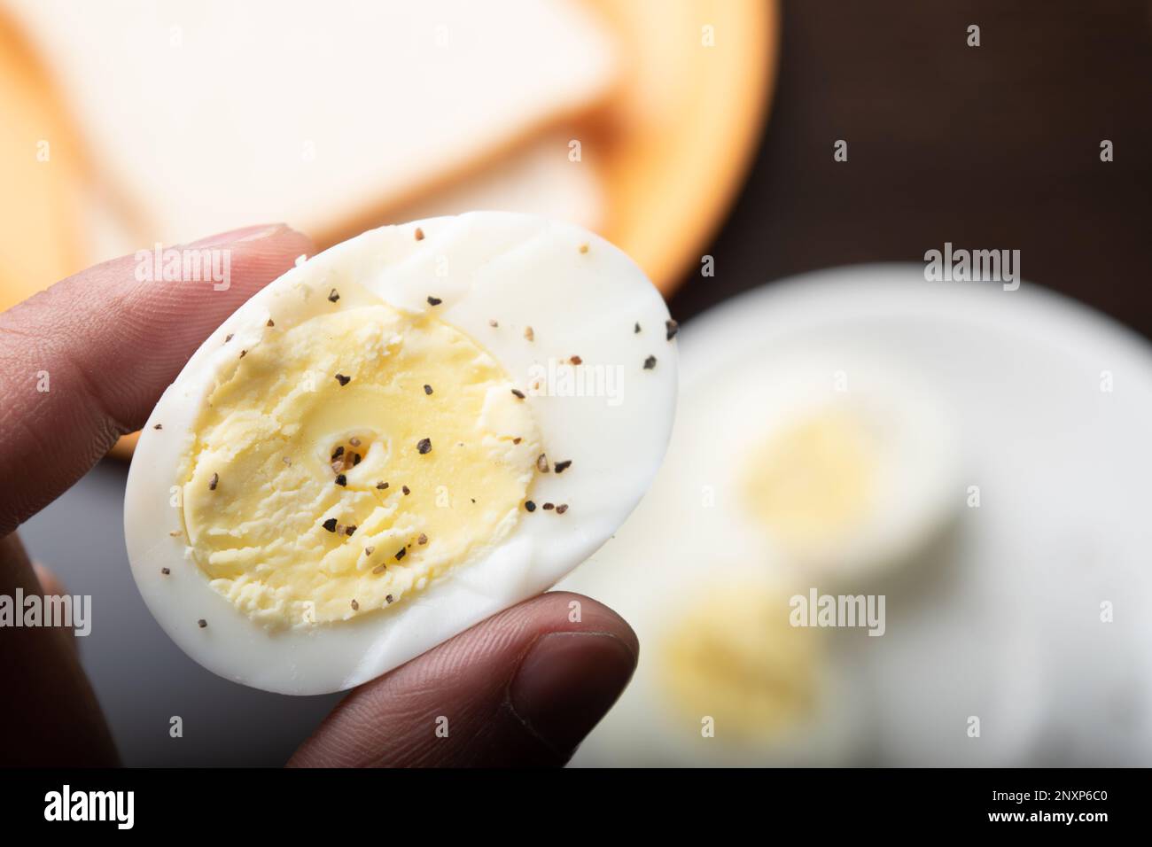 Slice of boil egg in hand, healthy food Stock Photo - Alamy