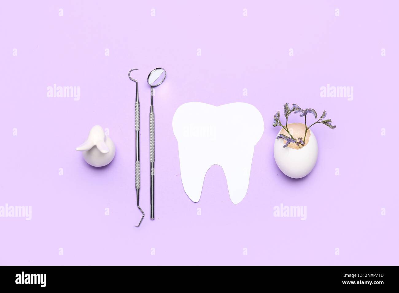 Paper tooth with dental tools, Easter rabbit, egg shell and flowers on ...