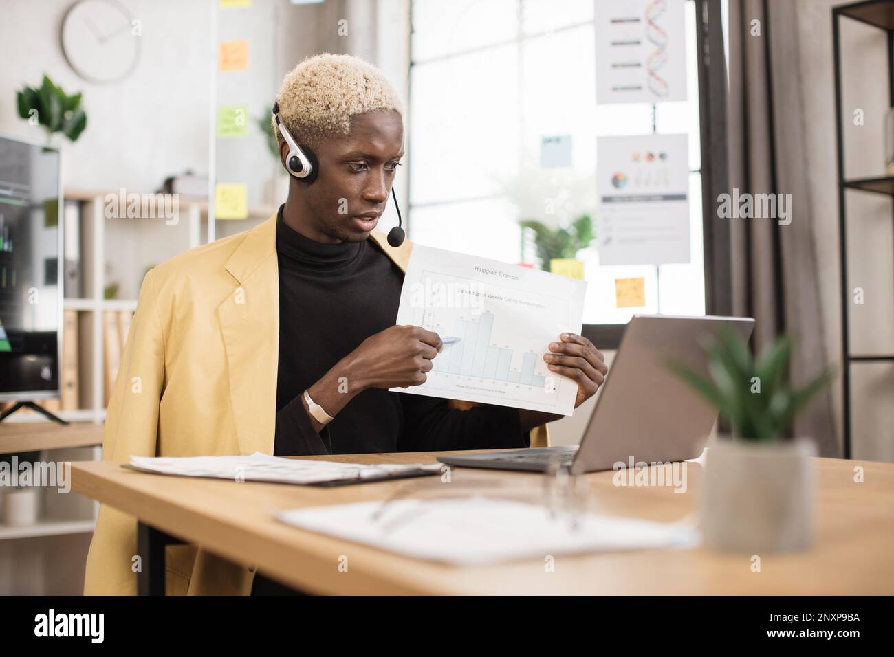 Serious marketing african man in suit and headset talking to client on ...