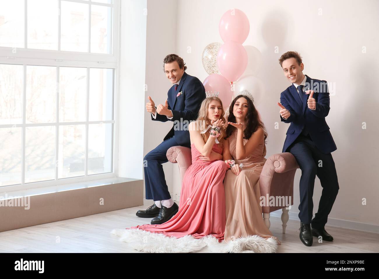 Beautiful couples dressed for prom in room Stock Photo - Alamy