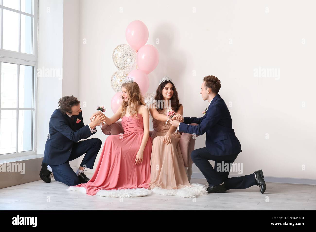 Beautiful couples dressed for prom in room Stock Photo - Alamy