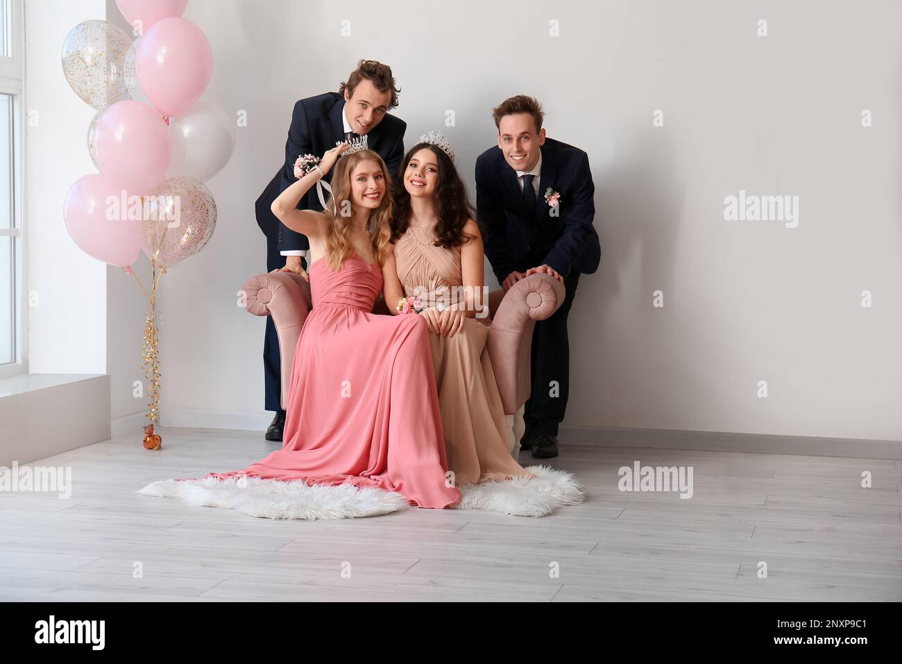 Beautiful couples dressed for prom in room Stock Photo - Alamy