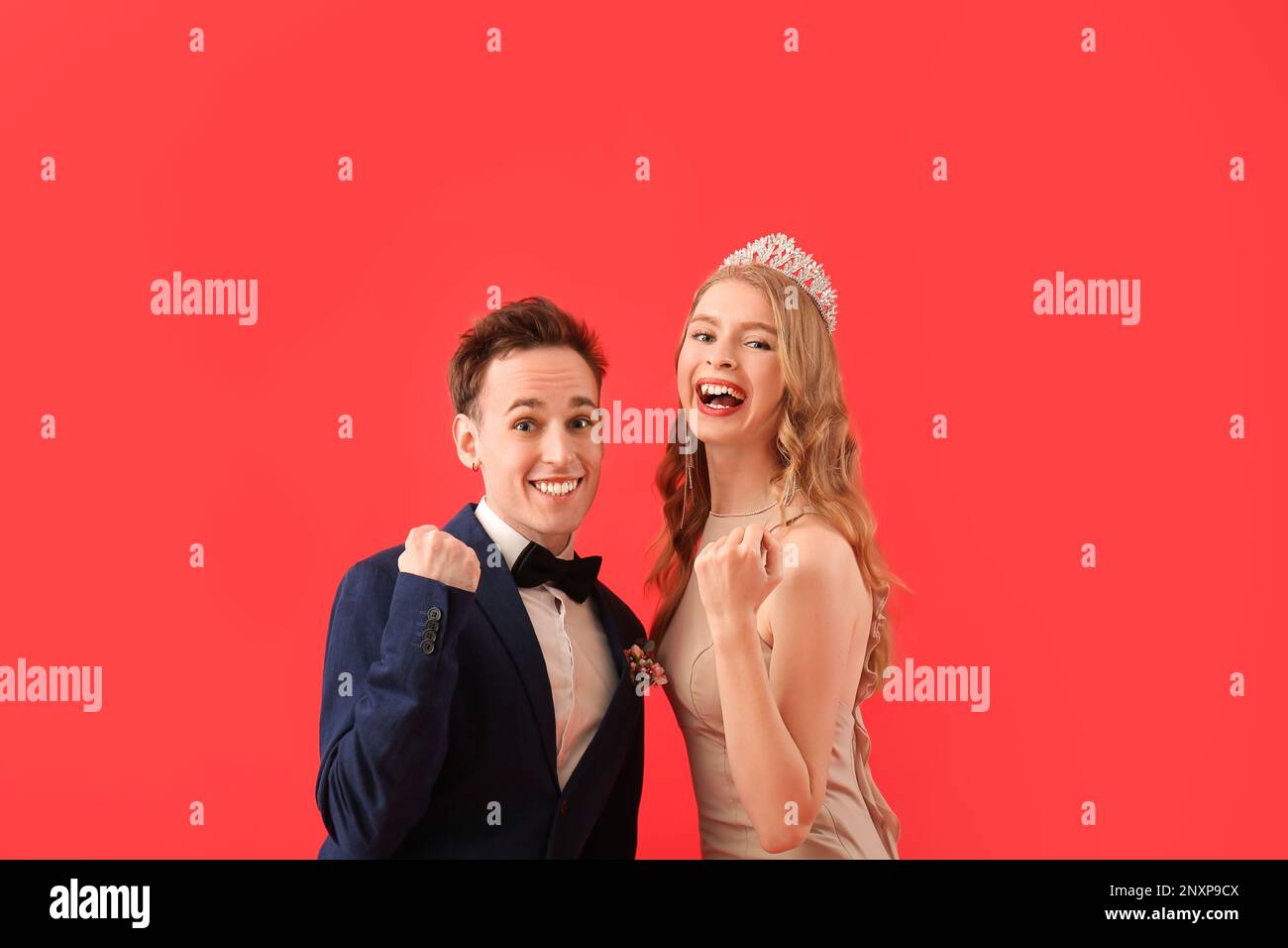 Happy young couple dressed for prom on red background Stock Photo - Alamy