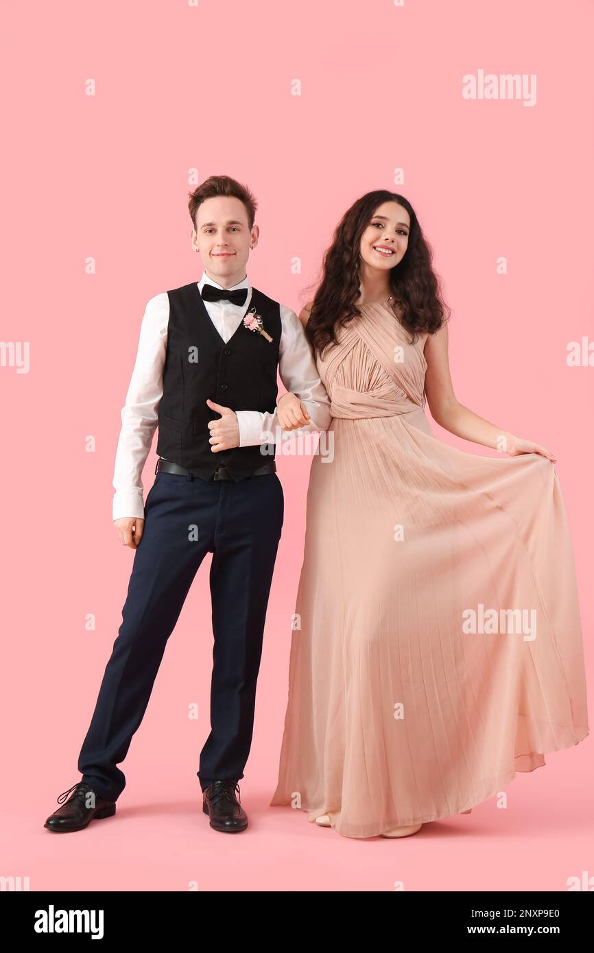 Beautiful couple dressed for prom on pink background Stock Photo - Alamy
