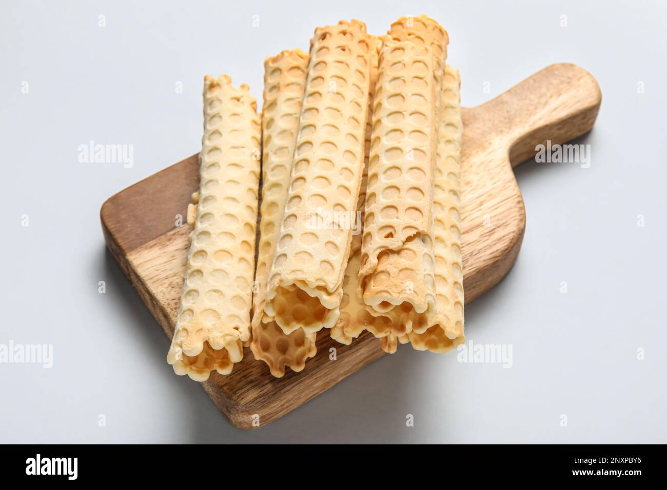 Board with delicious wafer rolls on grey background Stock Photo - Alamy