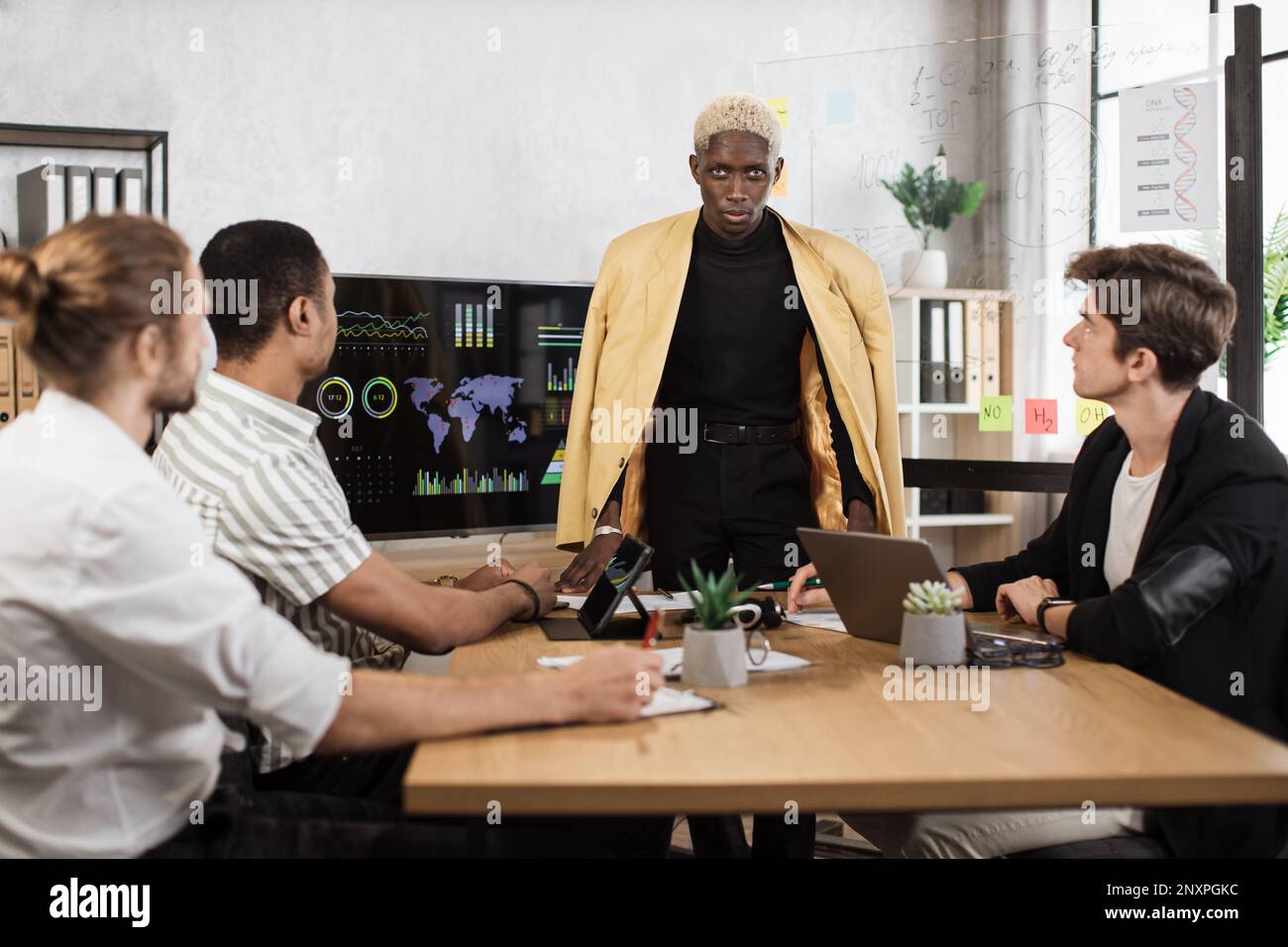 African man standing near big monitor and glass flip chart while ...
