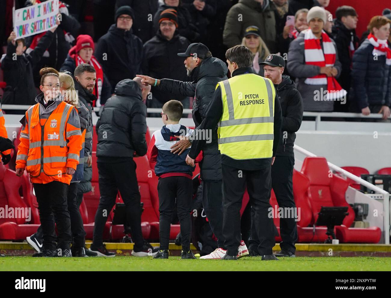 Liverpool manager Jurgen Klopp escorts a young pitch invader off the ...