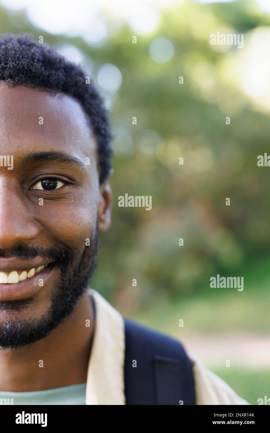 Vertical half face portrait of smiling african american man trekking in ...