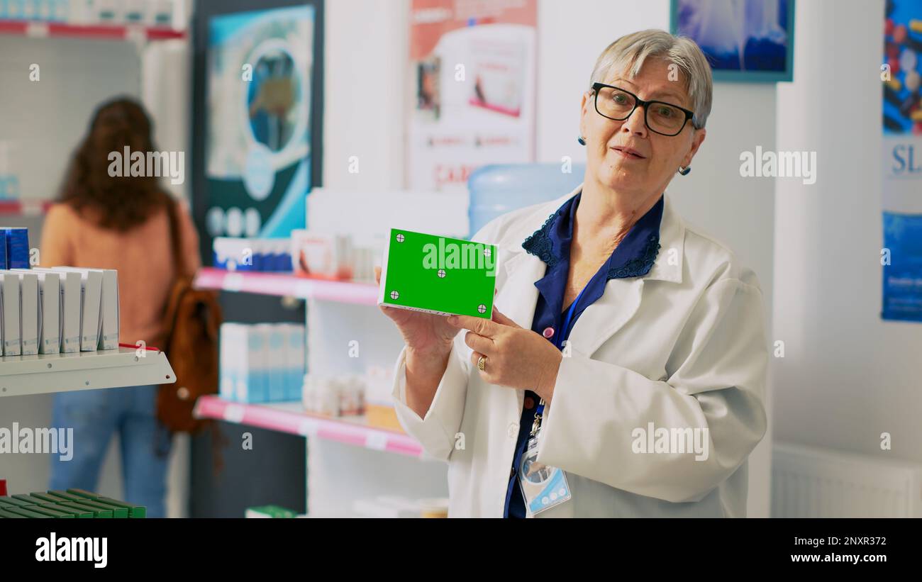 Medical assistant holding box of drugs with greenscreen, working in ...