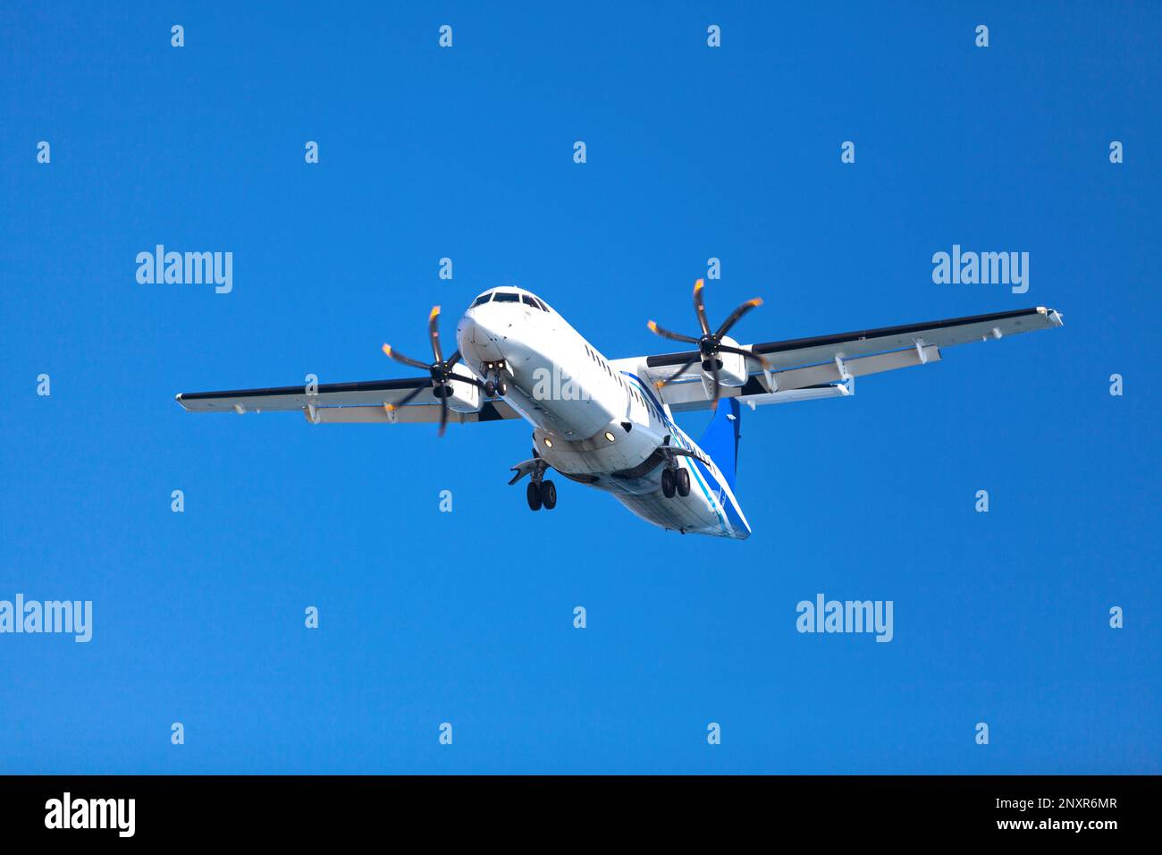 Front view of a commercial propeller airplane landing to the airport ...