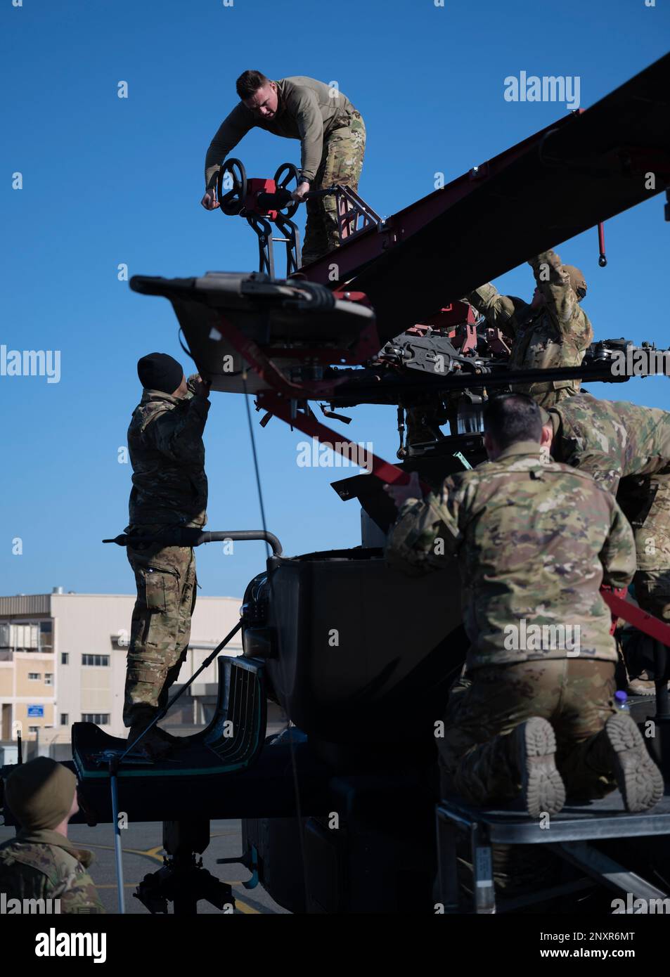 U.S. Army Soldiers from Task Force Rough Riders maneuver an AH-64E ...