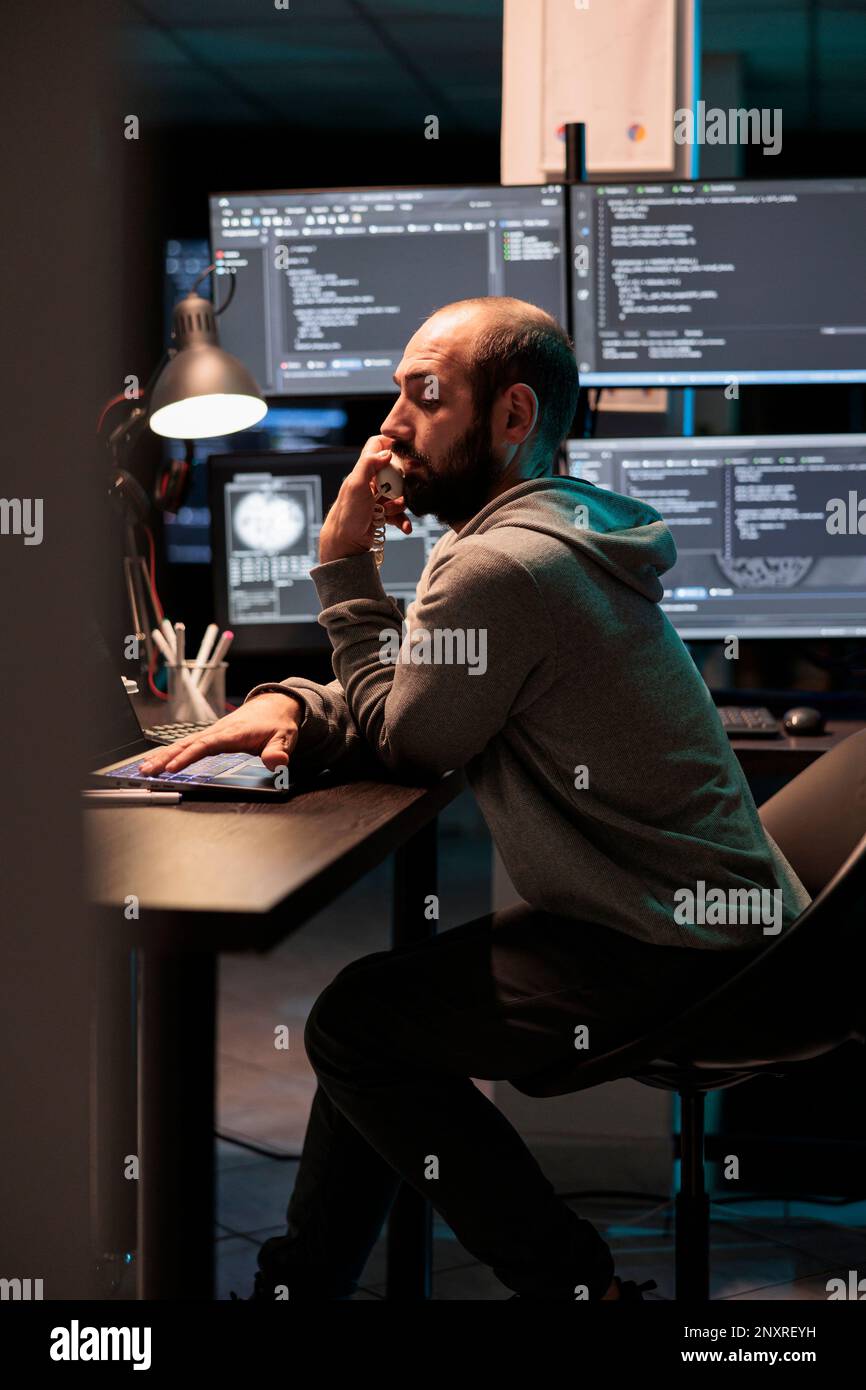 IT engineer answering landline phone call in office, talking about ...