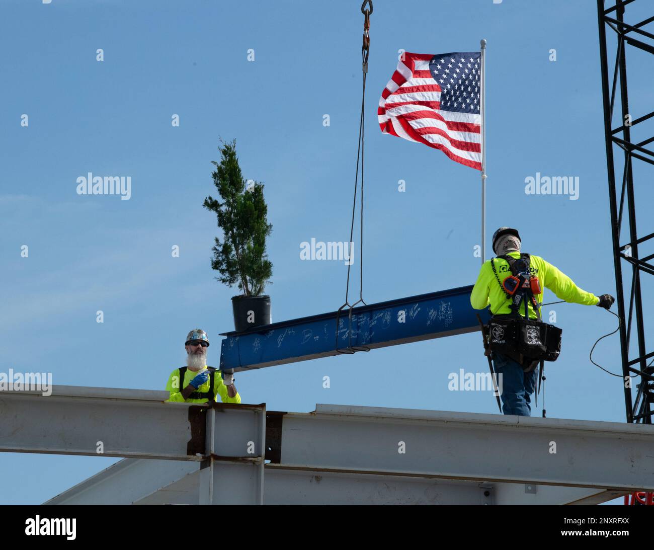 Steelworkers carefully align the ceremonial final beam to the future ...
