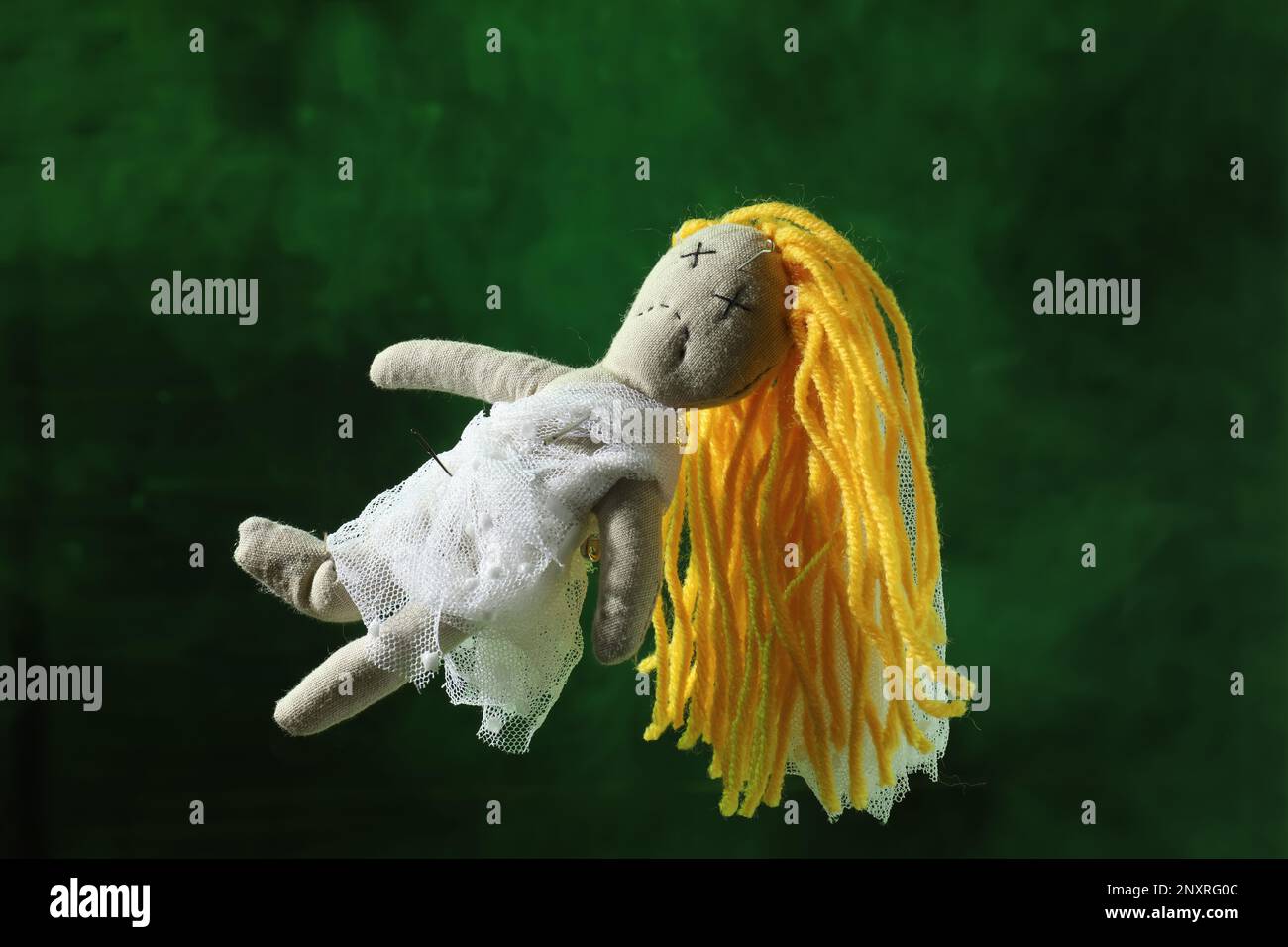 Female voodoo doll with pins and smoke on green background Stock Photo ...