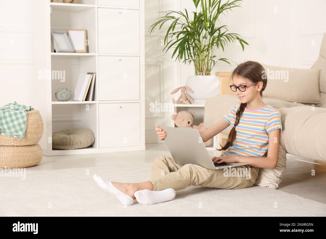 Cute girl sitting on carpet hi-res stock photography and images - Alamy