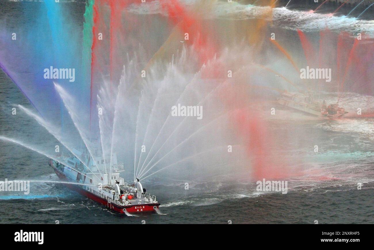 Firefighting ships spray colored water during Dezomeshiki, an annual ...