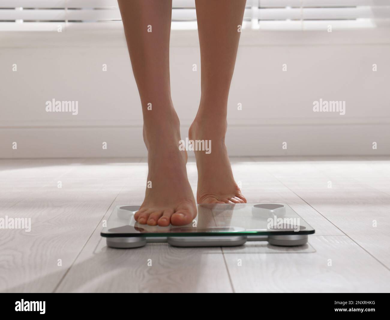 Woman stepping on floor scales indoors, closeup. Weight control Stock ...