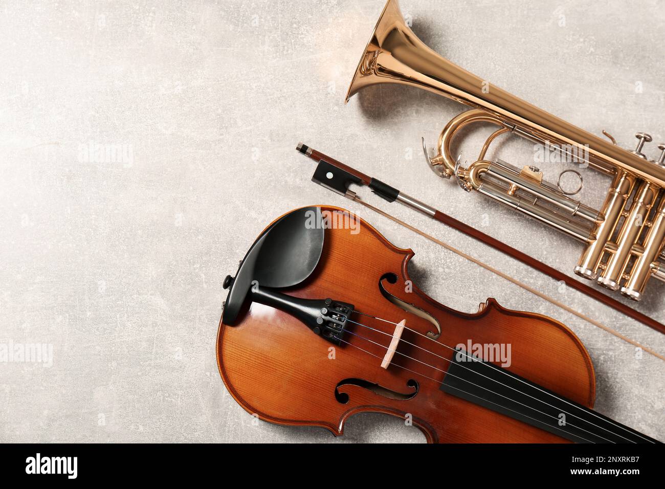 Violin and trumpet on light grey background, flat lay with space for ...
