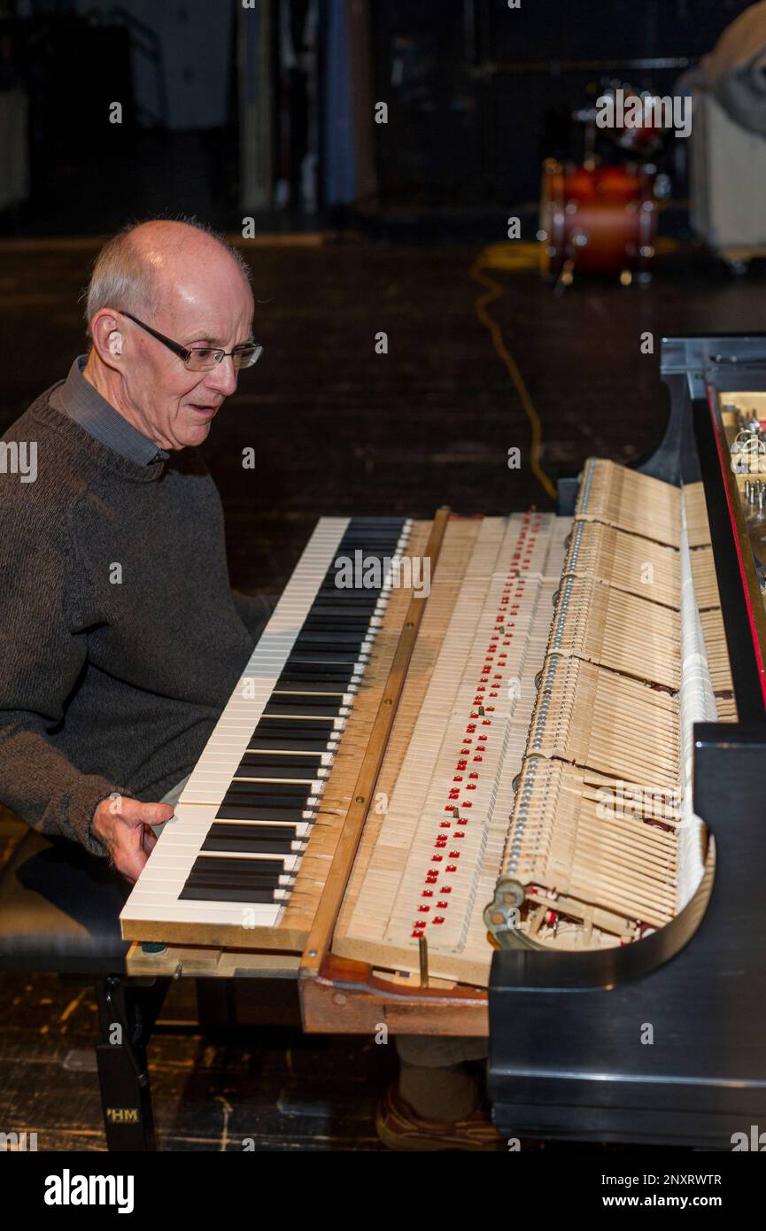 Richard Gorden pulls the keyboard out of the piano to check on the ...