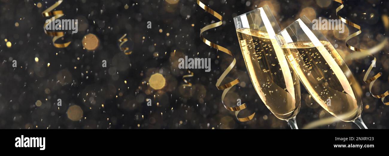 Glasses with sparkling wine and shiny serpentine streamers against ...