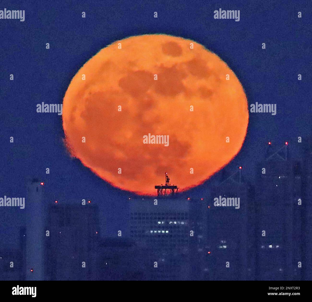 The full moon rises behind the buildings in Shinjuku Ward, Tokyo on Jan ...