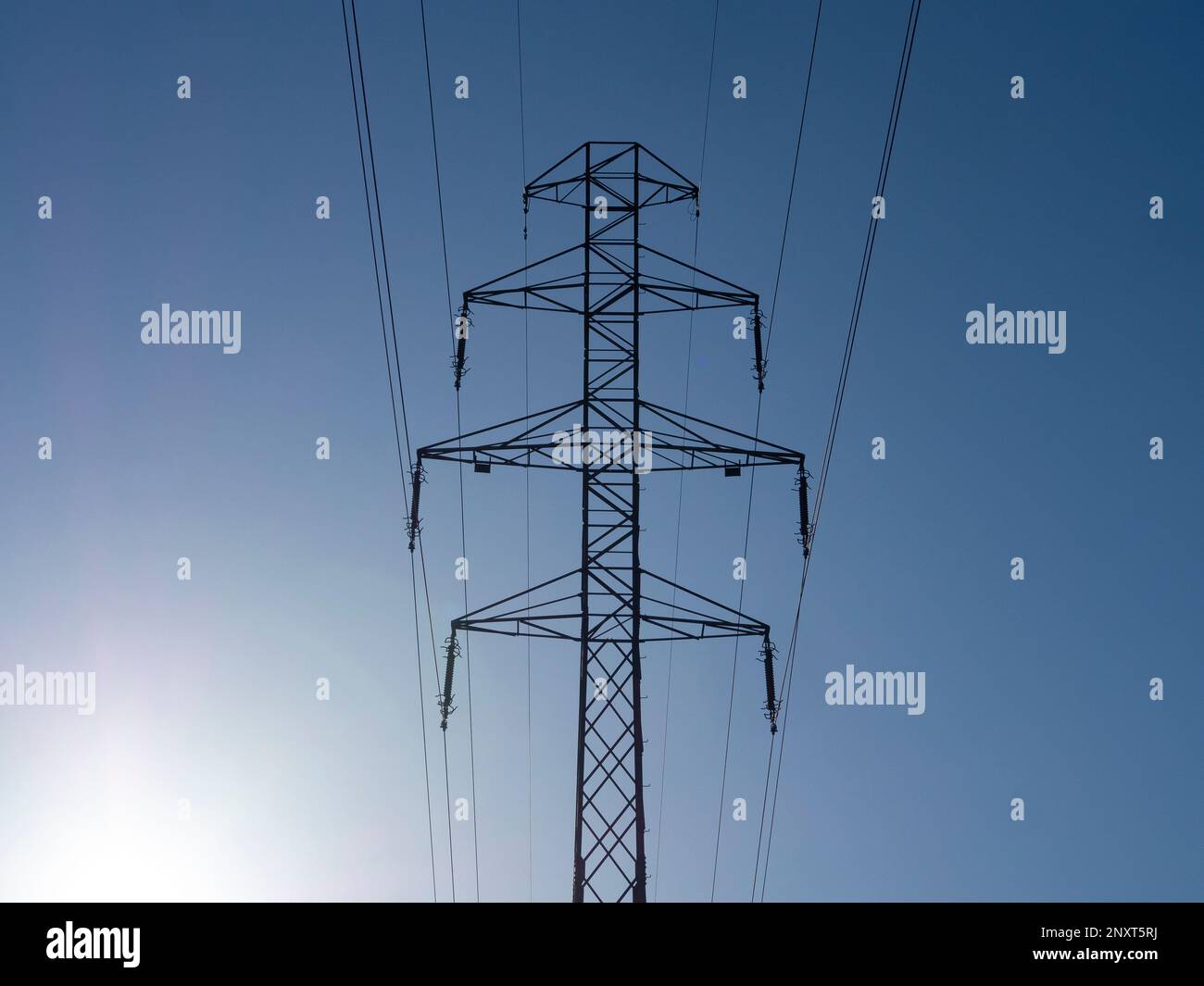 Photograph of the shape of a high-voltage pole taken against the sun ...