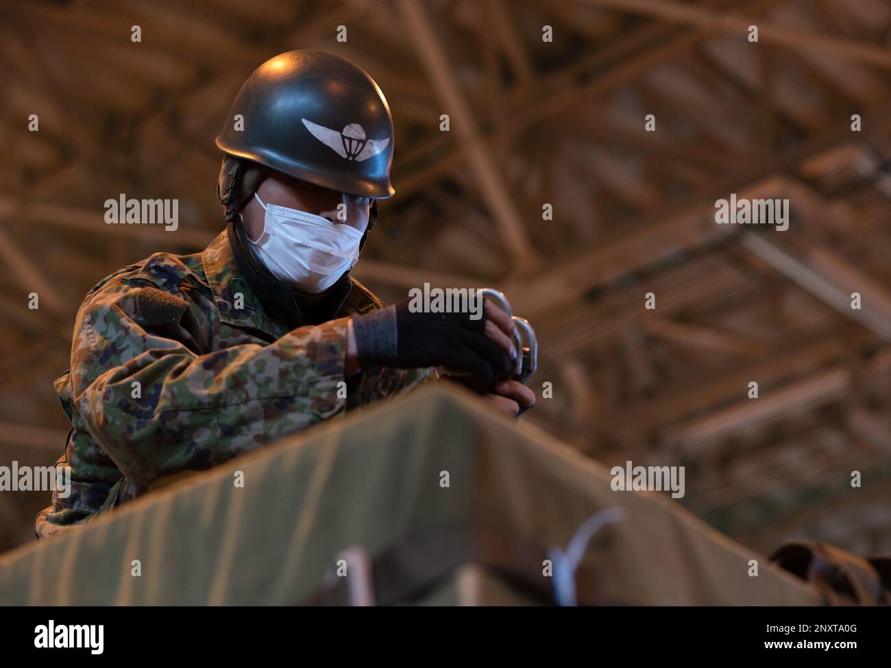 A soldier from the Japan Ground Self-Defense Force secures a bundle in ...